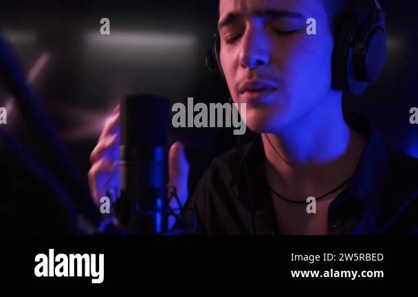 Singer records his composition in a music studio. Young Boy sings a ...