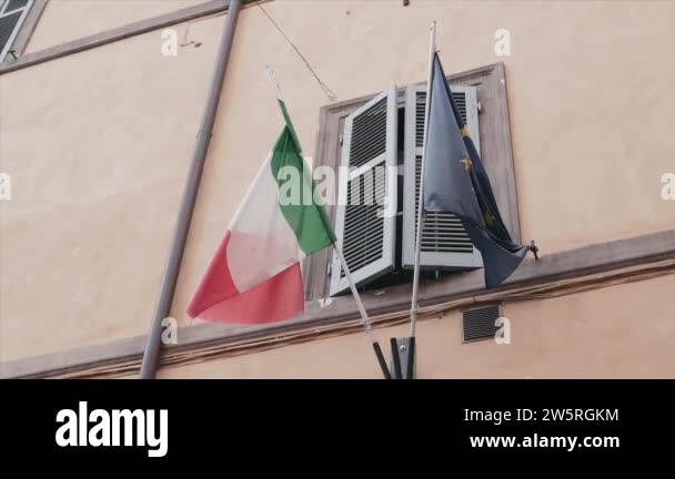 Flags of Italy and European Union hanging under the window shutters of ...