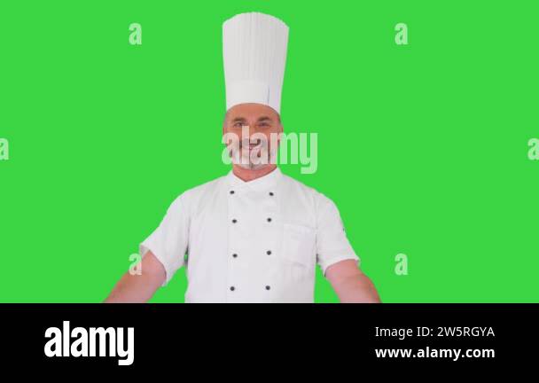 Professional chef man making welcome gesture to camera on a Green ...