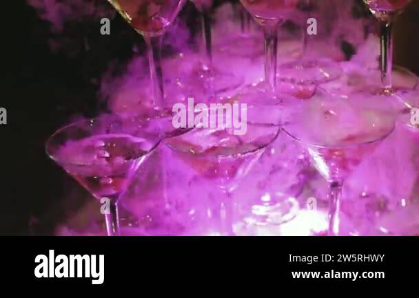 Glasses with alcoholic beverages in the pyramid, filling and pouring ...