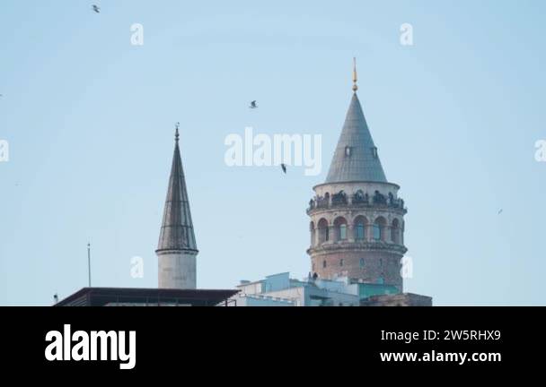 Galata Tower on background of city. Action. Ancient tower towers over ...