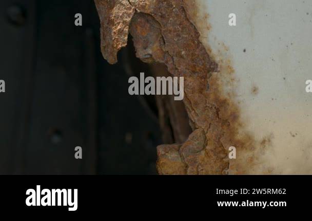 Deep rust on the body of a gray old car. Rust and corrosion hole on old worn out painted metal ...