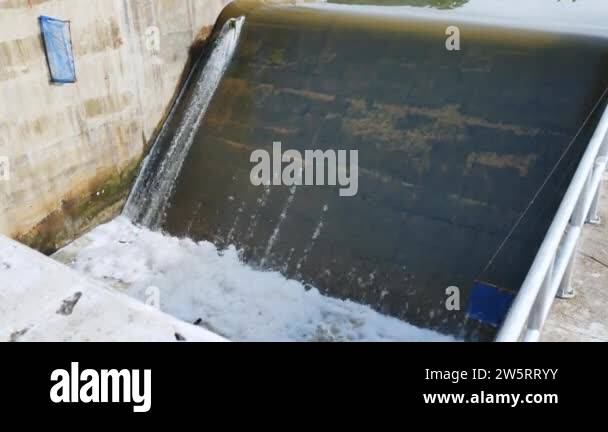 Closeup release of water from the dam. Aerial view of water flowing ...