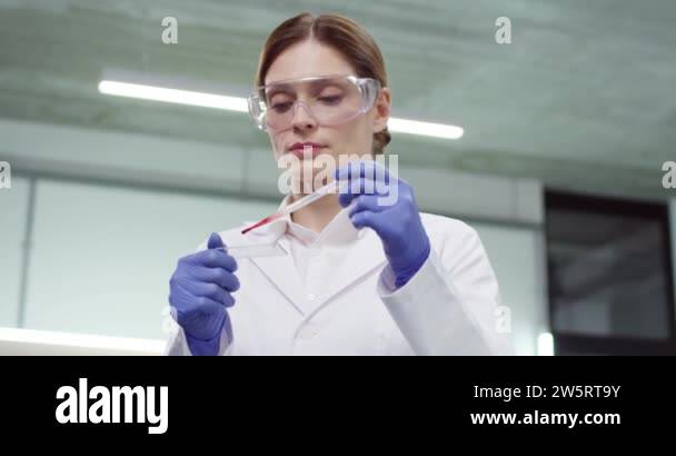 Close up of serious young Caucasian pretty female laboratory worker in ...