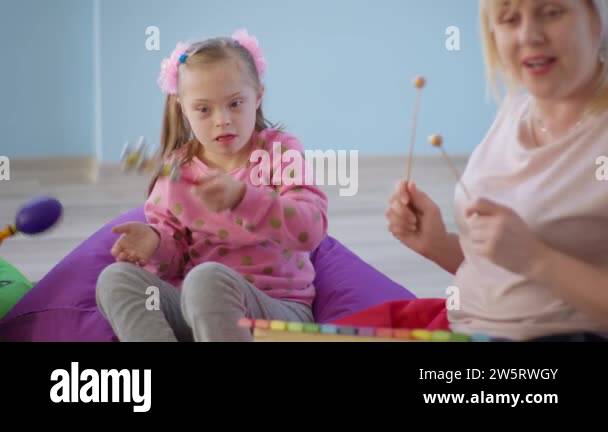 learning toys, little girl with down syndrome with bells playing with ...