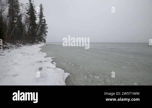 Very cold looking scene with a large lake full of pieces of floating ...