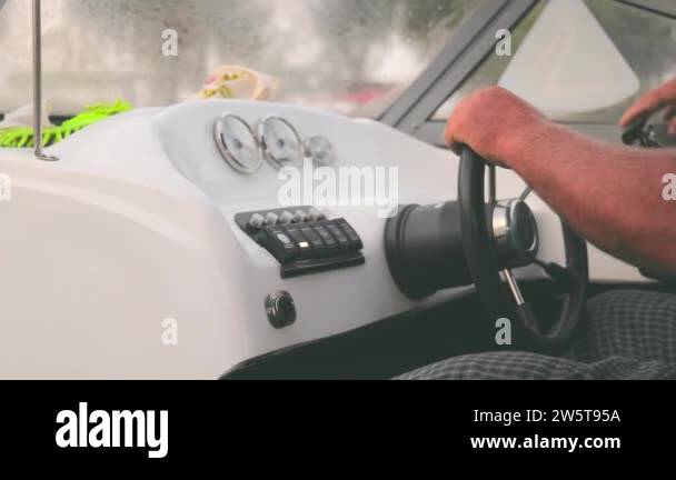 Hands of an older man driving the helm of a speedboat. Boat rudder and ...