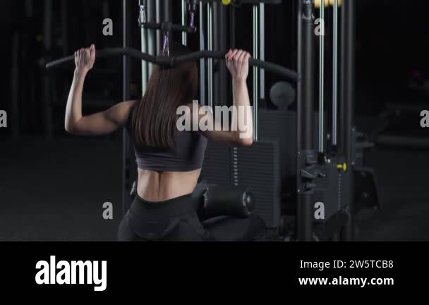 Woman in the Gym lifting blocks on rack machine, strength training on ...