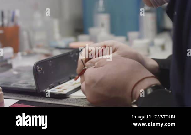 A dentist creates a model of a jaw prosthesis and ceramic teeth in the ...