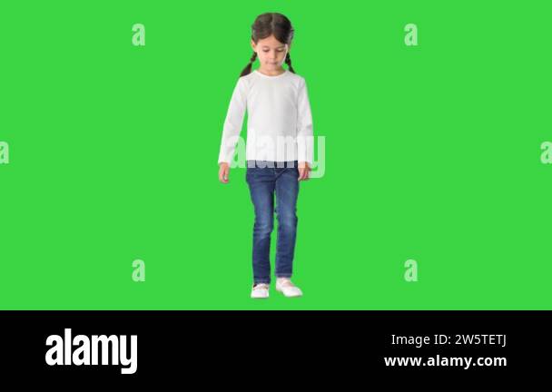 Little girl with pig tails dressed in white long sleeve top and jeans ...