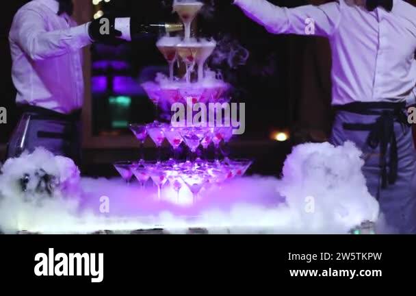 Glasses with alcoholic beverages in the pyramid, filling and pouring ...