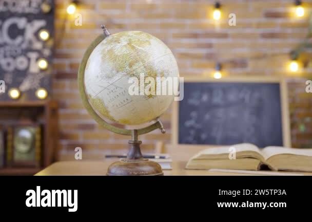 Interior of a modern empty classroom with globe, chalkboard, desk and ...