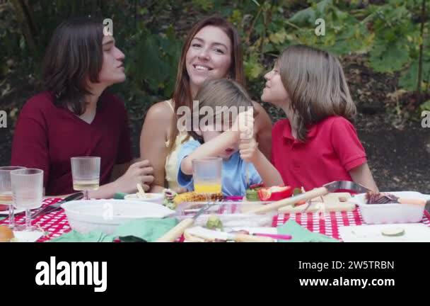 Medium shot of sons sitting around mother and kissing her. Family ...