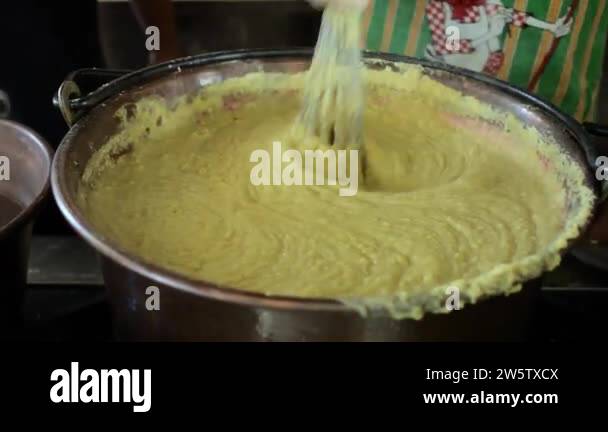 Boling and mixing in a copper cualdron a traditional hominy food called ...