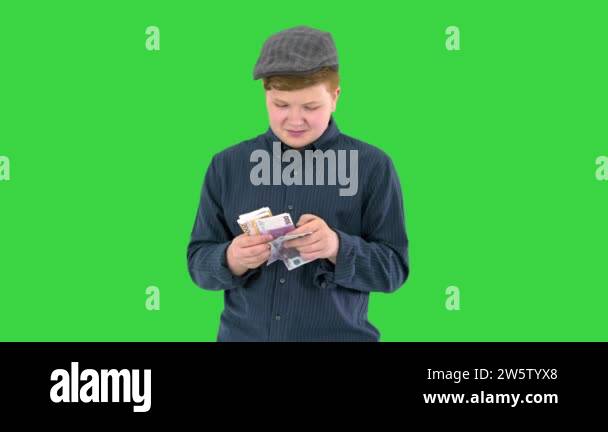 Rich teenager in a cap counting euros on a Green Screen, Chroma Key ...