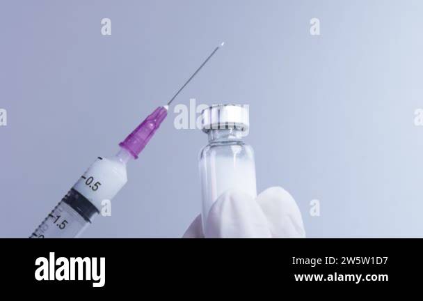 Close up shot of a milky white vaccines are pouring out of syringe ...