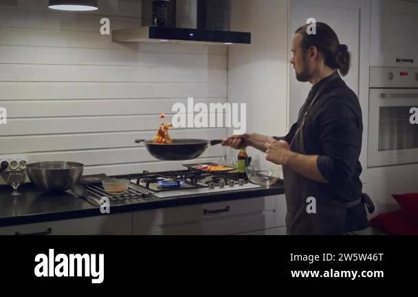 Roasting vegetables and chicken in a wok over a fire. Cooking Asian ...