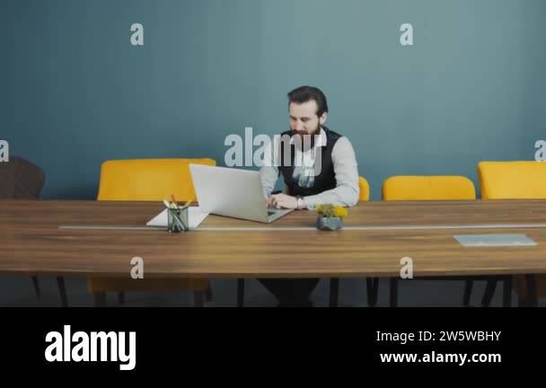 Young bearded man programmer Caucasian appearance, sitting and working ...