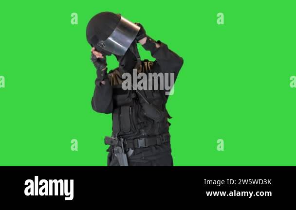 Police officer in full protection riot gear putting on helmet on a ...