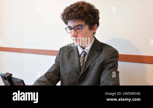 A young Caucasian boy is dressed as a reporter and is preparing to do a ...