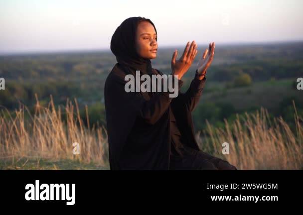 4k Black muslim woman praying on the carpet. Solat praying on the ...