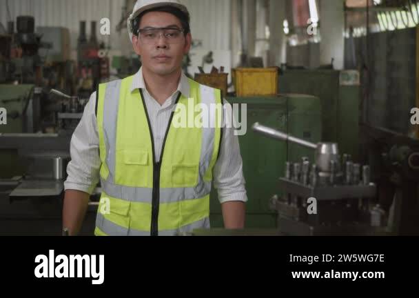 Portrait Asian engineer man worker wear safety goggles control lathe ...