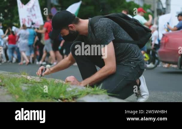 Masked riot activist man drawing poster sign, poster banner. Rebel on ...