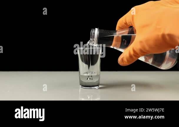 Chemical experiment, mixing Potassium Permanganate (KMno4) into a glass ...