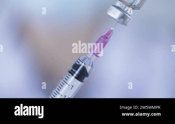 Close up nurse doctor use syringe injection needle sucking liquid ...