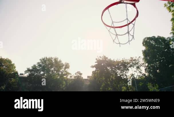 Male hand shot ball into basketball hoop. Ball scoring goal into basket ...