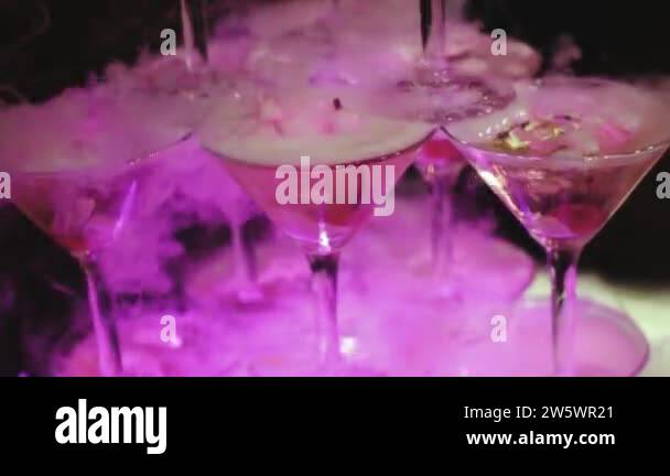 Glasses with alcoholic beverages in the pyramid, filling and pouring ...