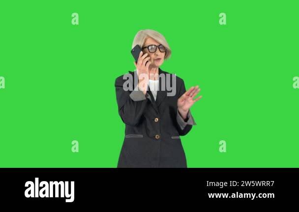 Stylish focused busy grey-haired lady ceo boss chief calling on a Green ...
