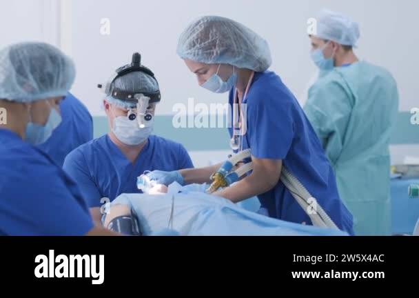 The anesthesiologist and medical team prepares female patient for ...