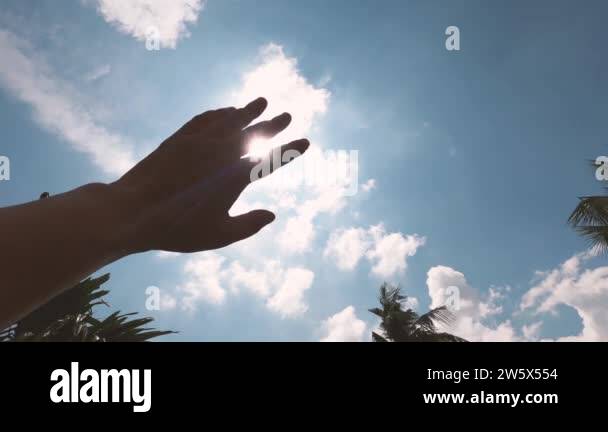 Hot summer sunlight rays pouring through human hand. Hand covering sun ...