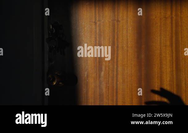 Scary shadow of a hand on the door. Silhouette of a thief hand trying ...