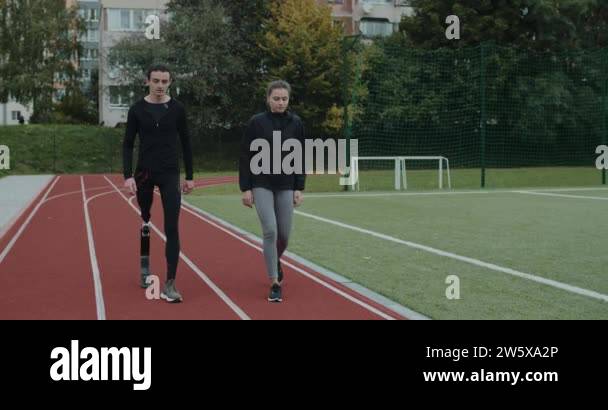 Young woman and disabled man walking and taking position on marks at ...