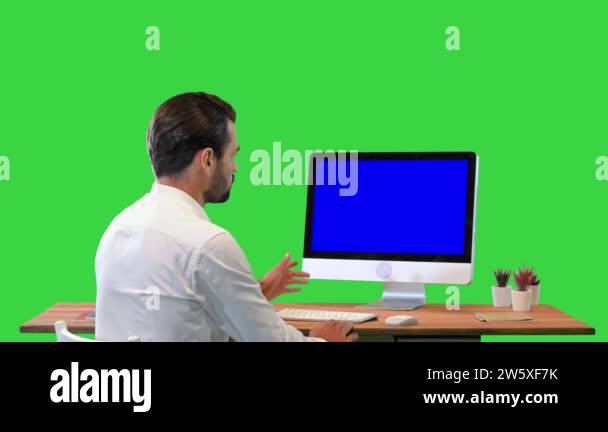 Business man sitting next to monitor and presenting something talking ...