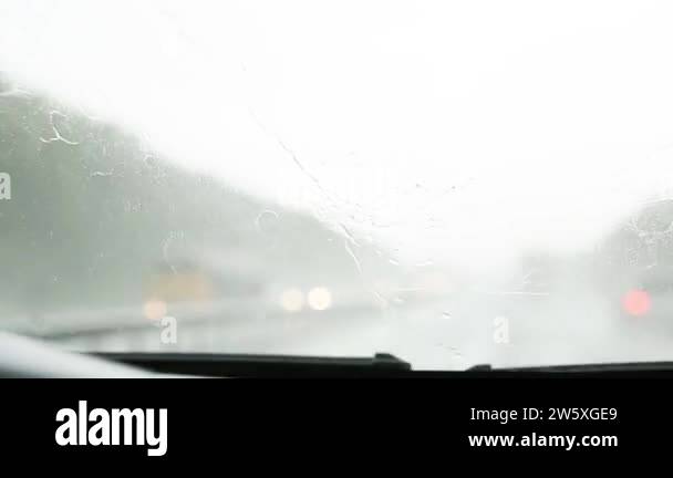 Driving car in conditions of limited visibility: heavy rain, wipers ...