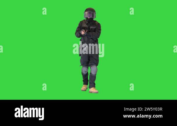 Anti terrorist or riot unit walking and aiming with a pistol on a Green ...