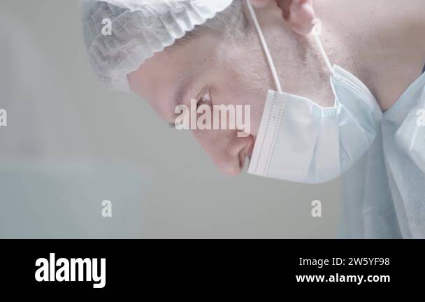 Close-up of masked surgeon during surgery. Action. Young professional ...