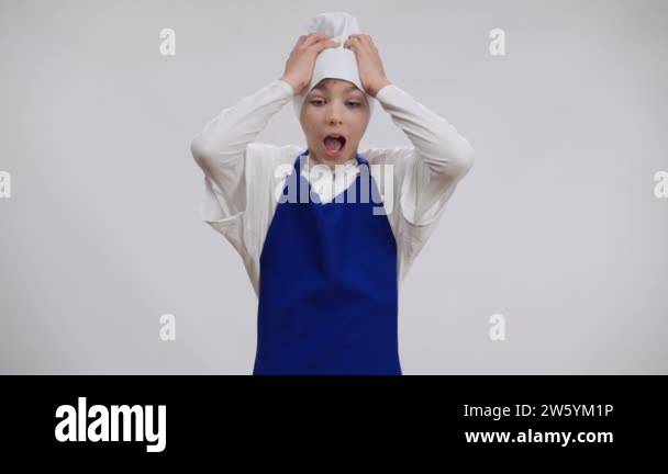 Scared little chef screaming holding head in hands posing at white ...