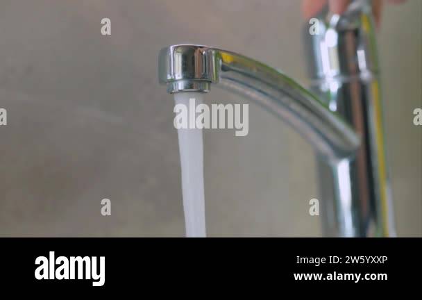 Tap water flows from the tap. Drinking water at the tap. Faucet in the ...