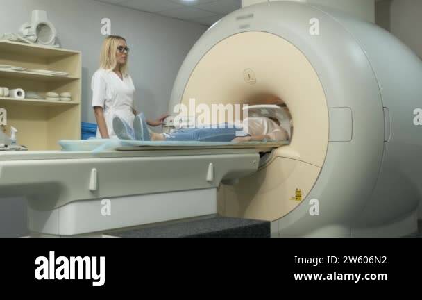 Woman doctor radiologist makes brain, head, neck MRI scanning. Young ...