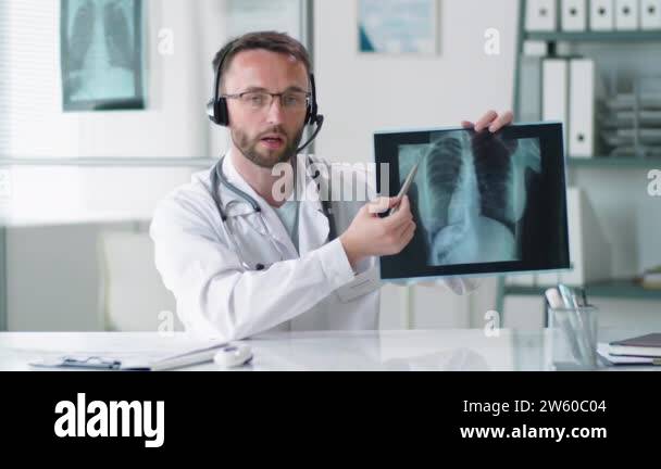 Experienced male doctor in lab coat, glasses and wireless headset ...