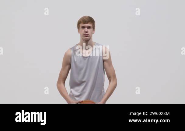 Portrait of a young basketball player looking at the camera and holding ...