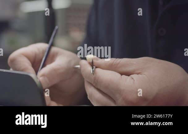 A dentist creates a model of a jaw prosthesis and ceramic teeth in the ...