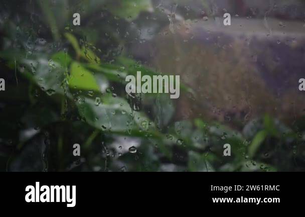 Falling raindrops on the glass window panes show the rain falling on ...