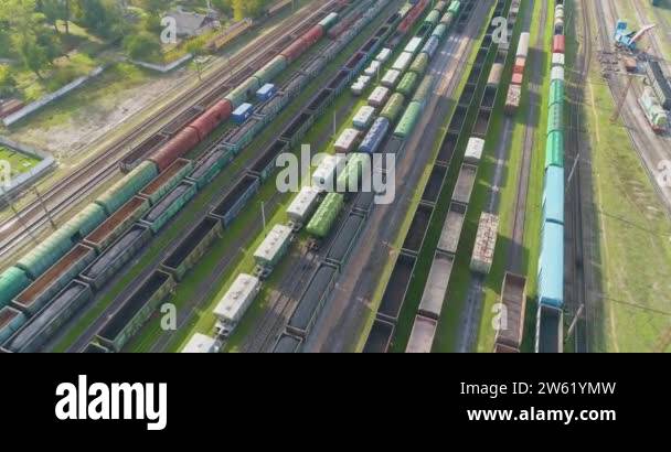 Fly over a large railway junction. Freight trains stand at the railway ...