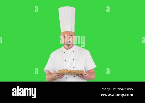 Senior cook with a pizza in hands walking on a Green Screen, Chroma Key ...