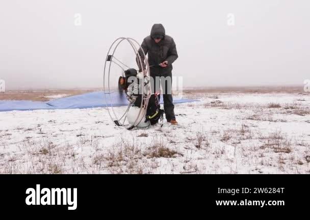 Man starts to work a propeller, motor, engine of the paramotor ...